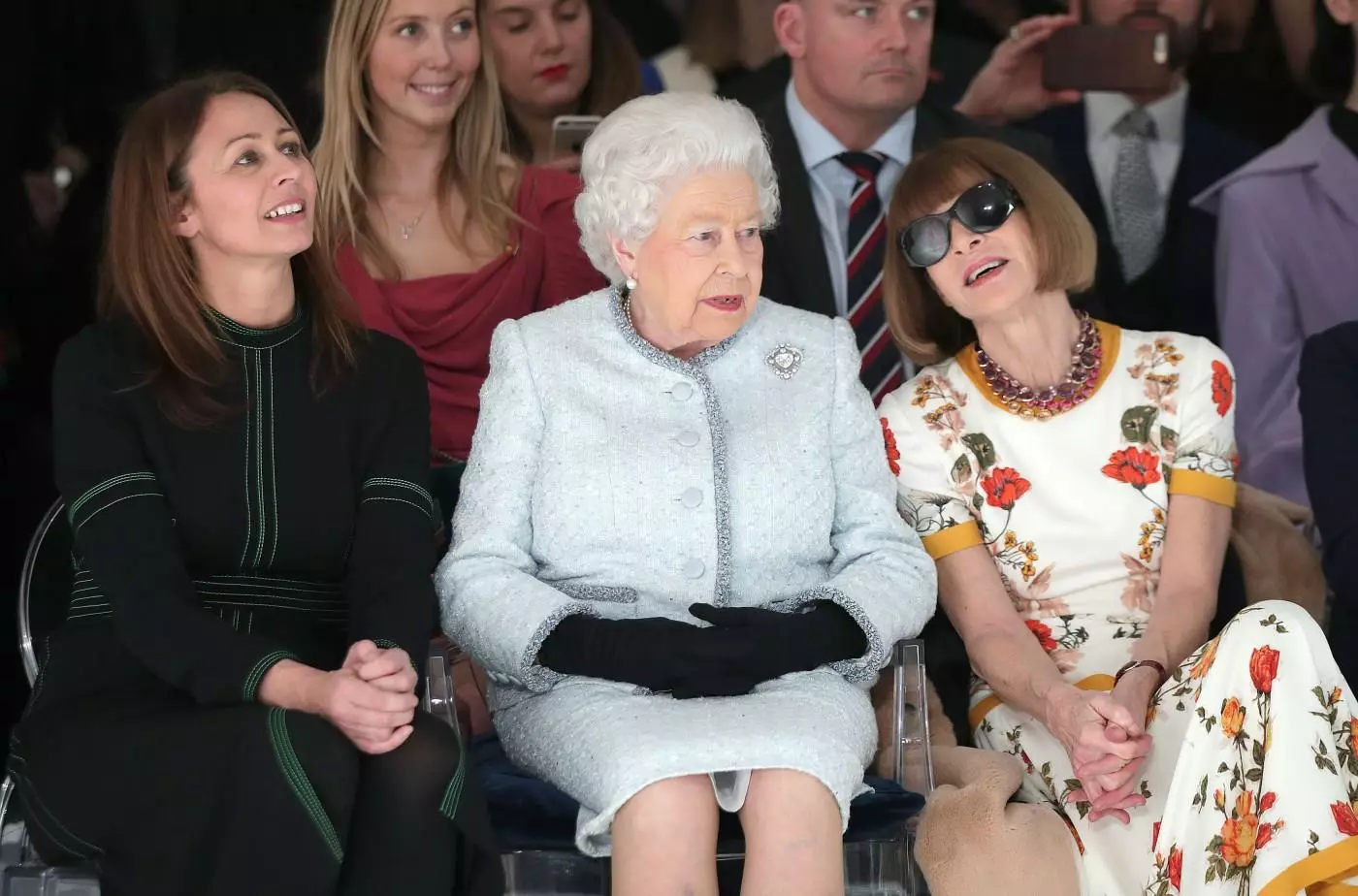 लंदन फैशन वीक में अन्ना विंटोर के बगल में प्लास्टिक के सिंहासन पर बैठी महारानी एलिजाबेथ द्वितीय 20146_2